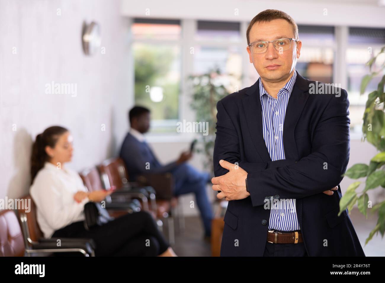 Dispassionate secretary man stands at reception with folder and list of ...