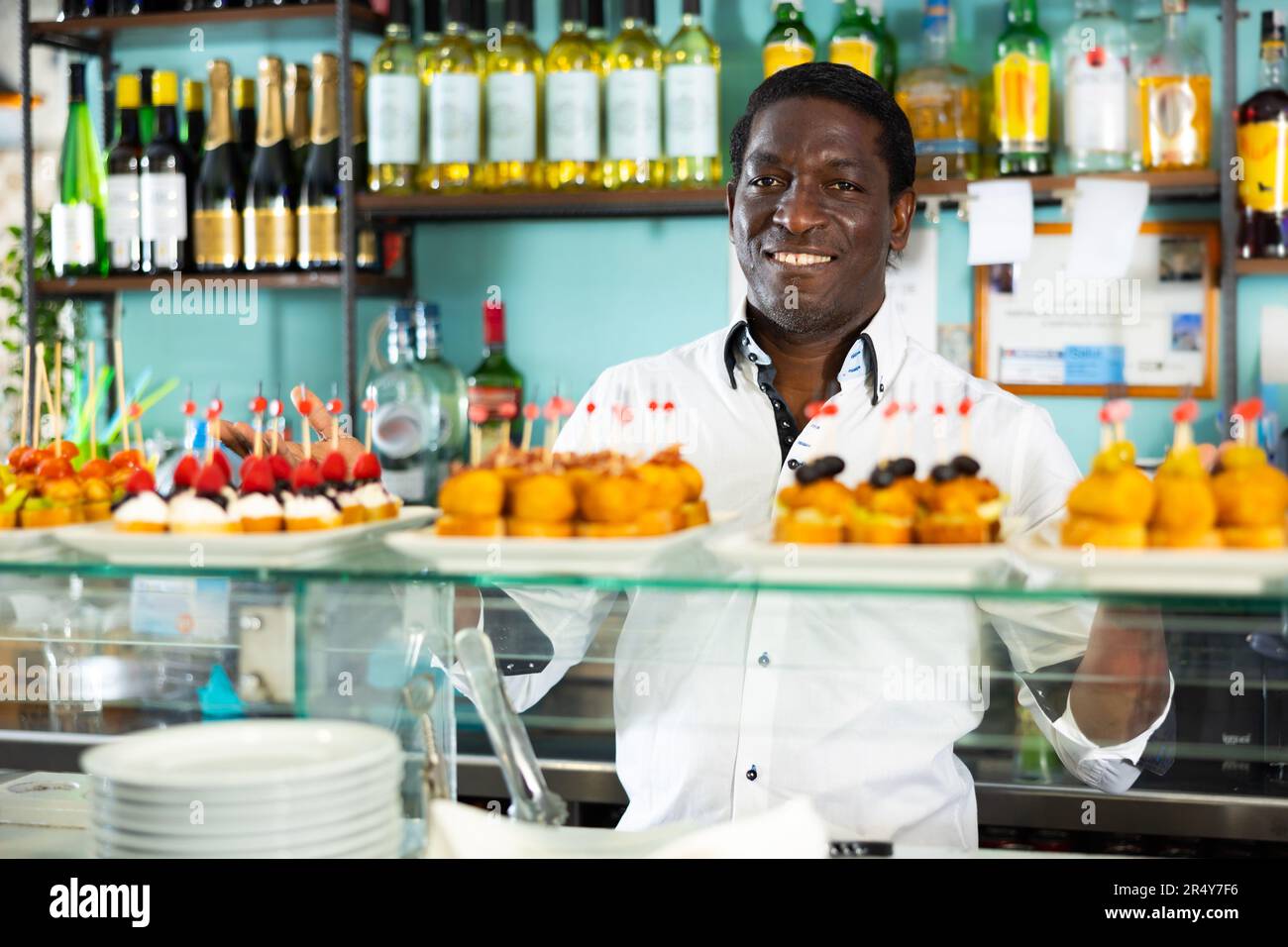 African american male bartender standing behind bar counter in pub and ...