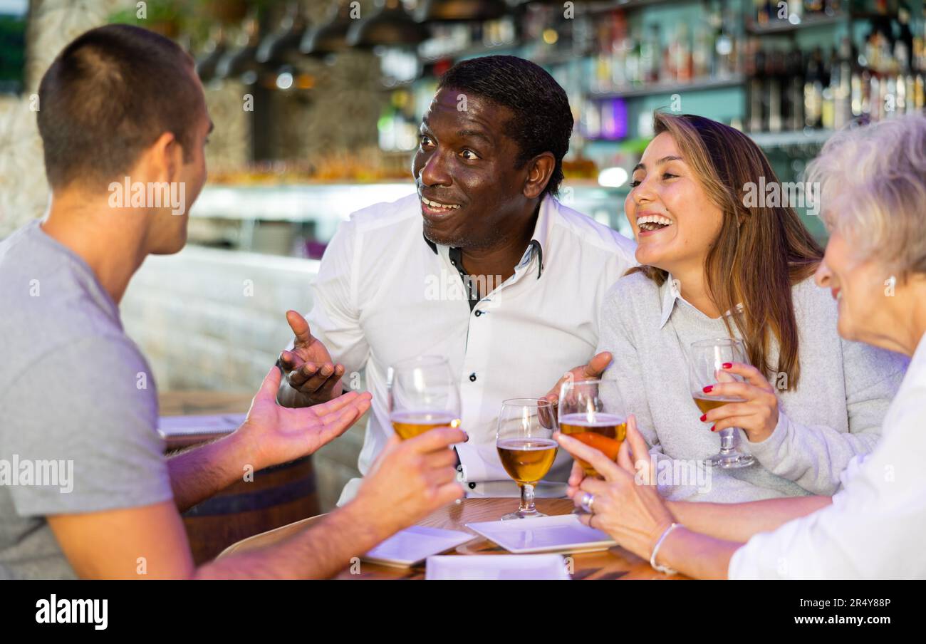 Diverse friends talking and laughing at a pub Stock Photo - Alamy