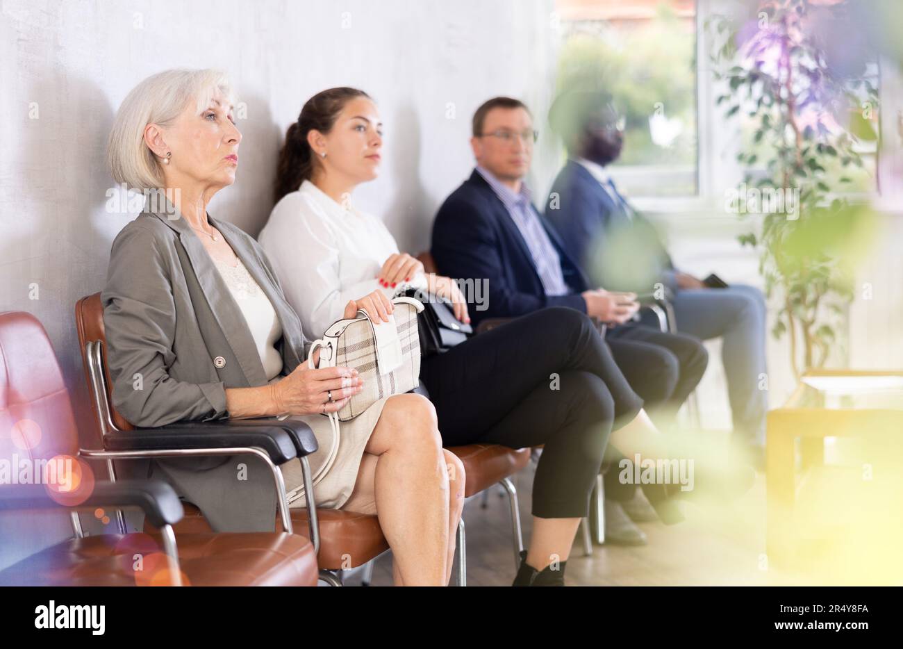 Serious-minded mature female candidate siting on chair and waiting for ...