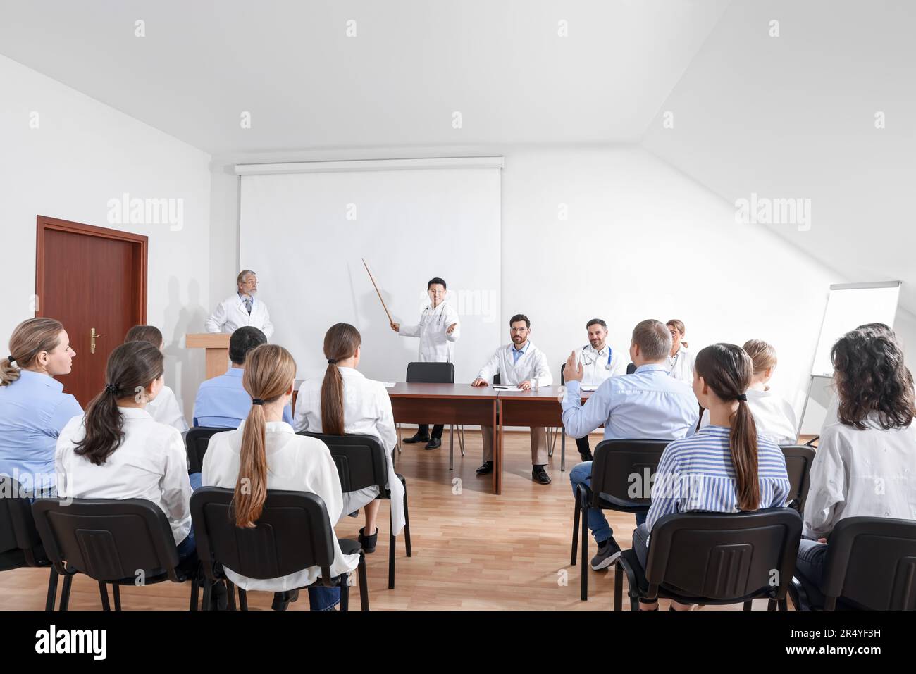 Doctors giving lecture near projection screen in conference room Stock ...