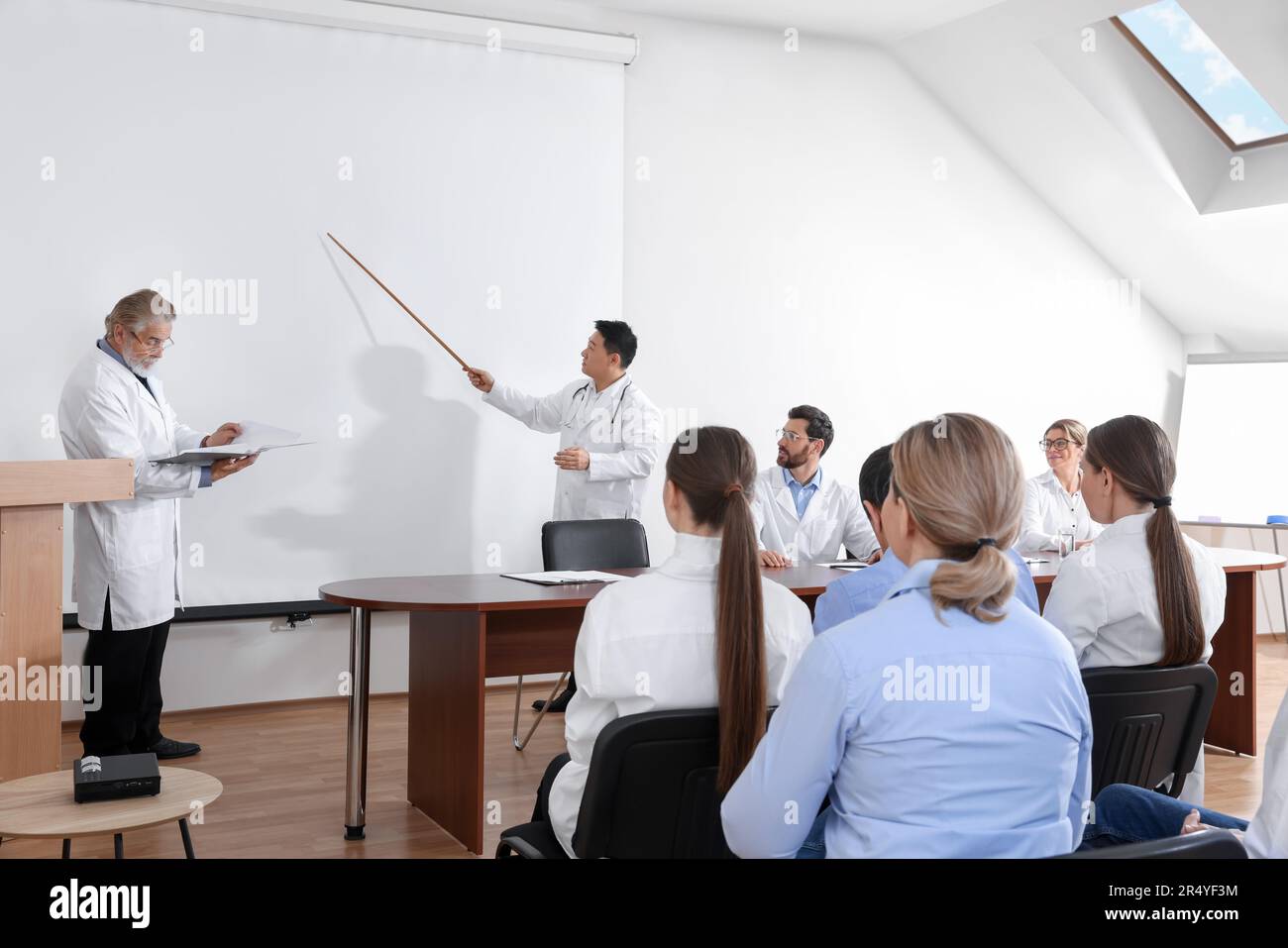 Doctors giving lecture near projection screen in conference room Stock ...
