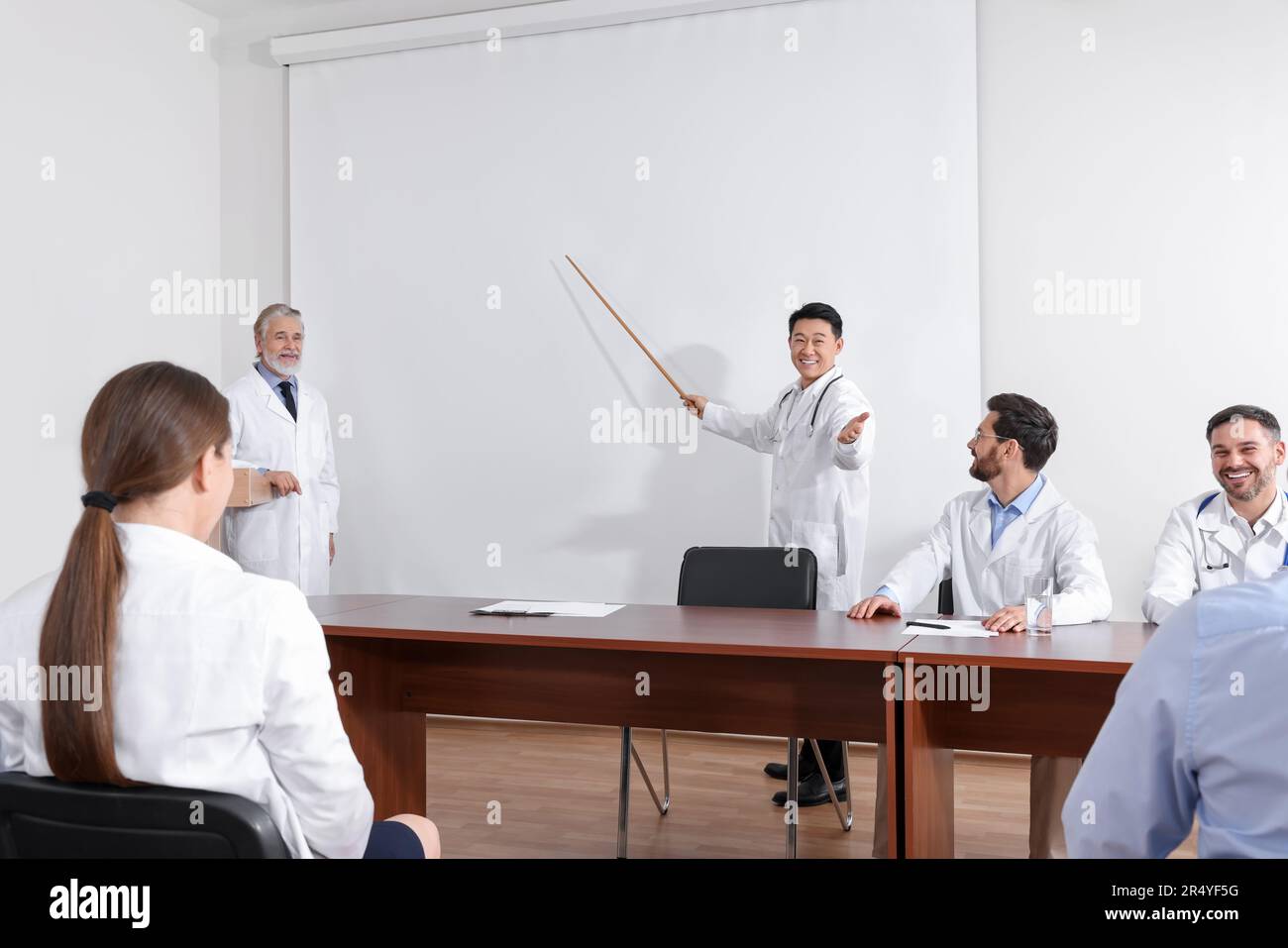 Doctors giving lecture near projection screen in conference room Stock ...