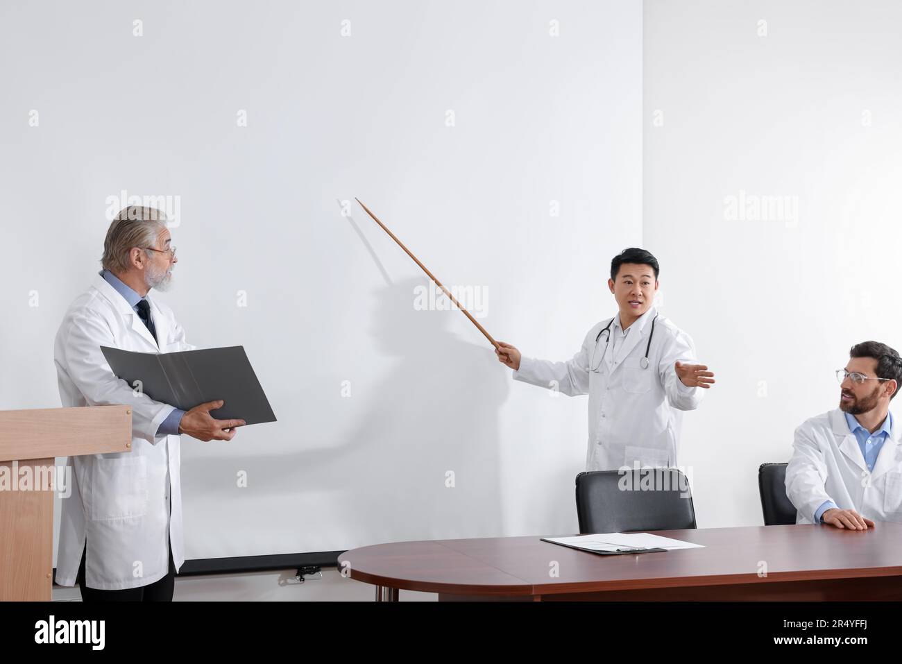 Doctors giving lecture near projection screen in conference room Stock ...