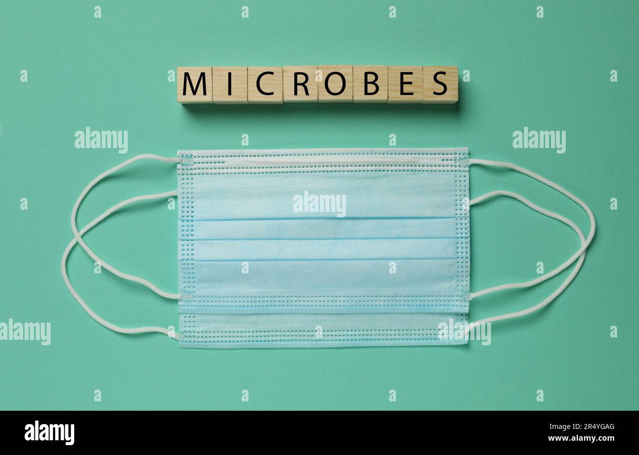 Word Microbes made with wooden cubes and face masks on turquoise ...