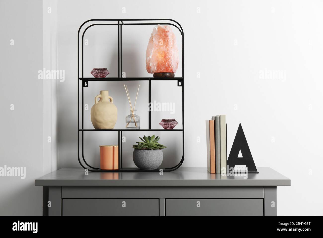 Shelving unit with decorative elements and books on chest of drawers ...