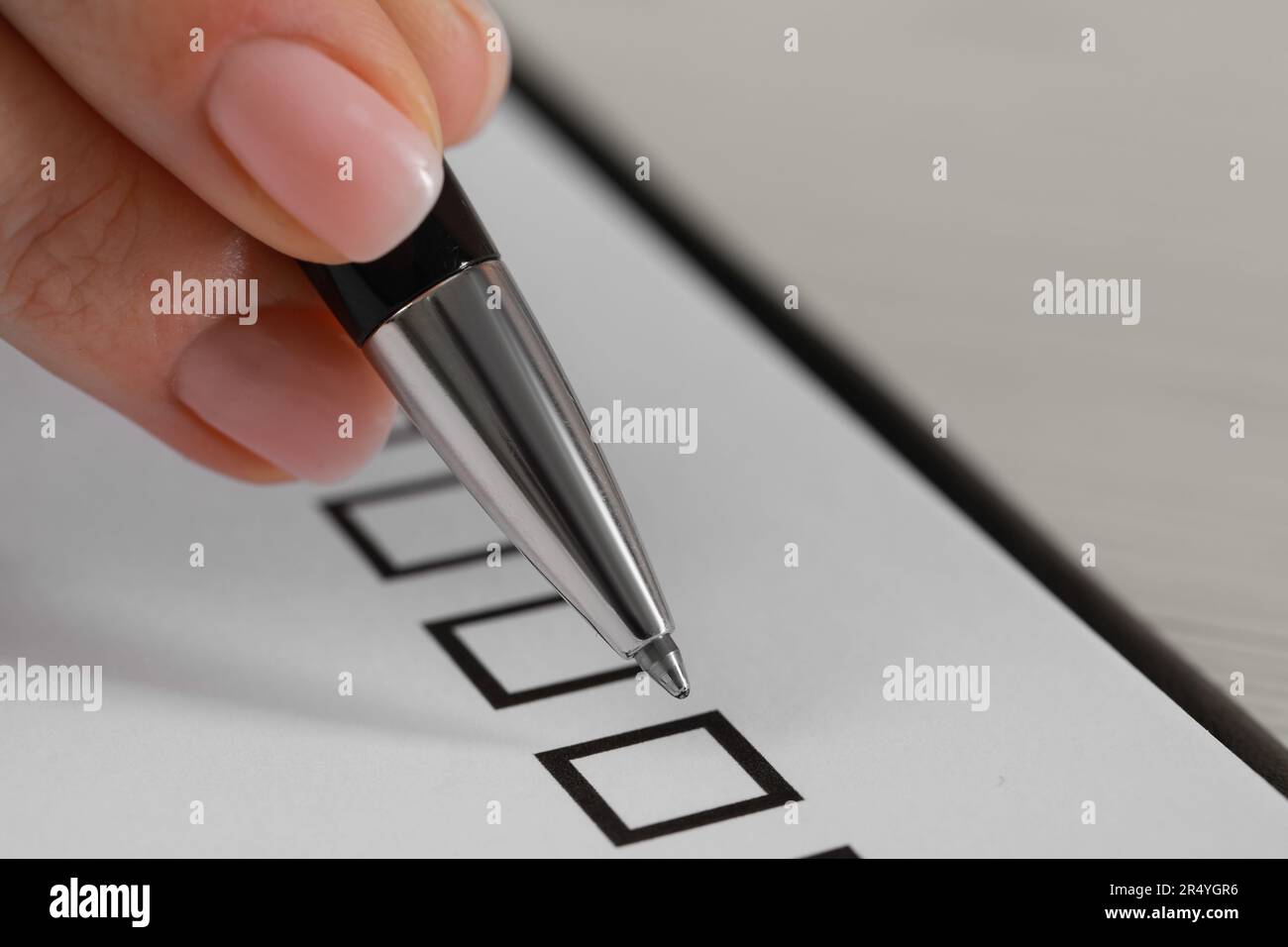 Woman filling check boxes with pen, closeup. Space for text Stock Photo ...