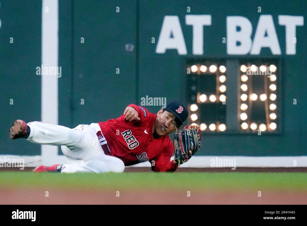 Boston Red Sox left fielder Masataka Yoshida rolls while fielding a fly ...