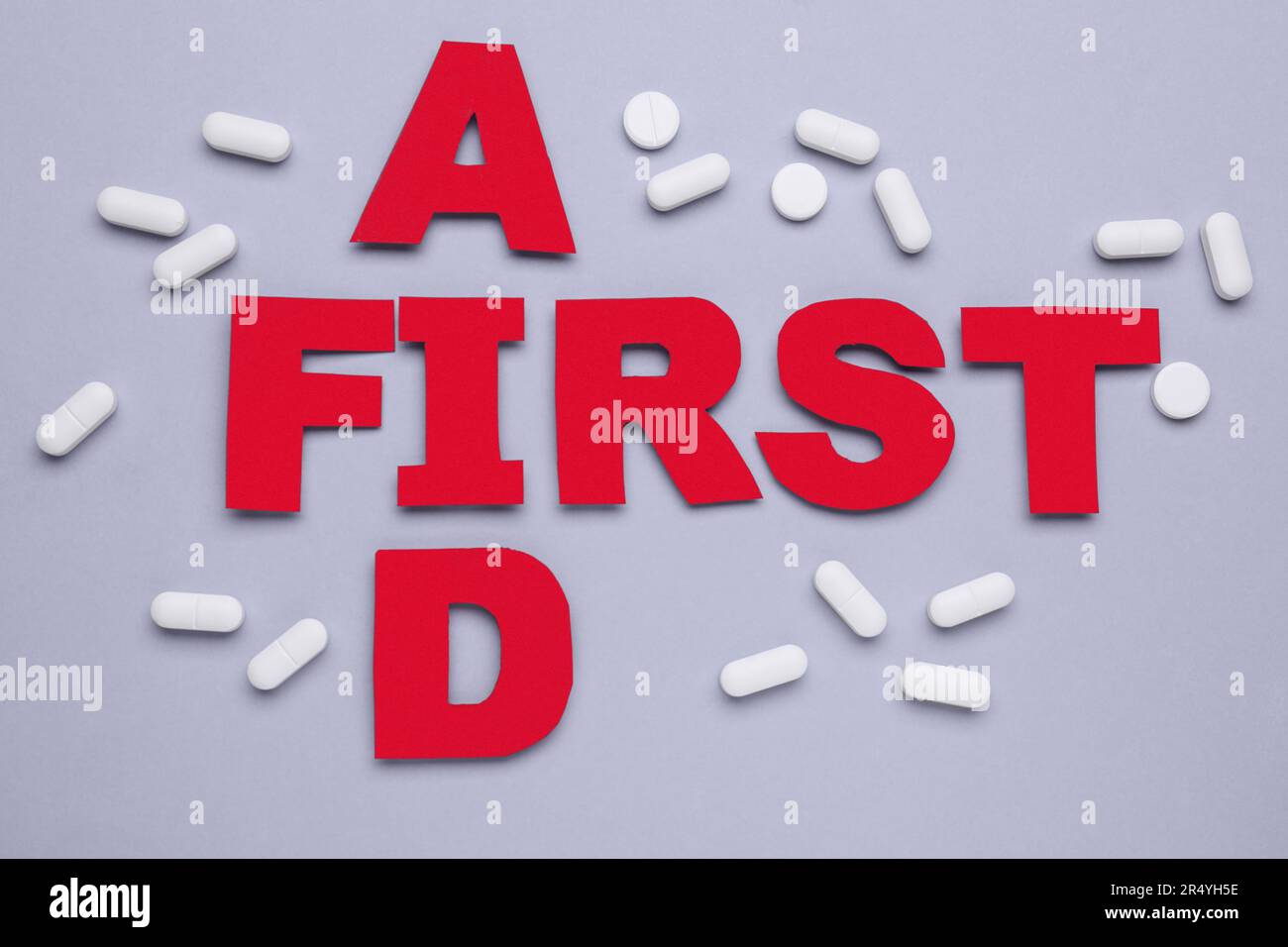Words First Aid made of red letters and pills on grey background, flat ...