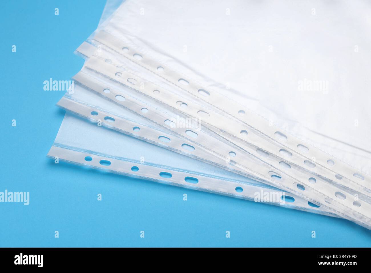 Punched pockets on light blue background, closeup Stock Photo - Alamy