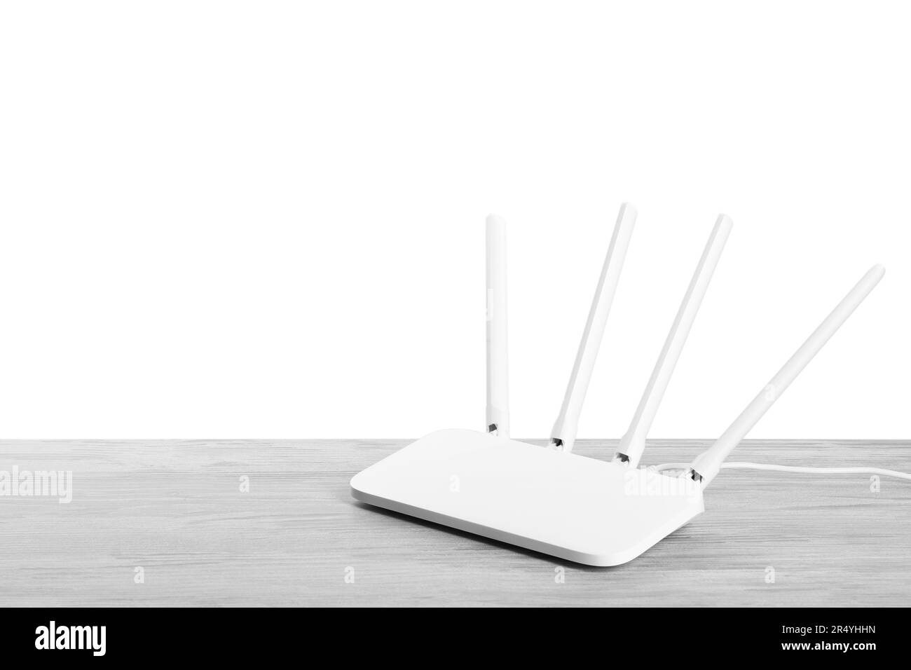 New modern Wi-Fi router on light wooden table against white background ...