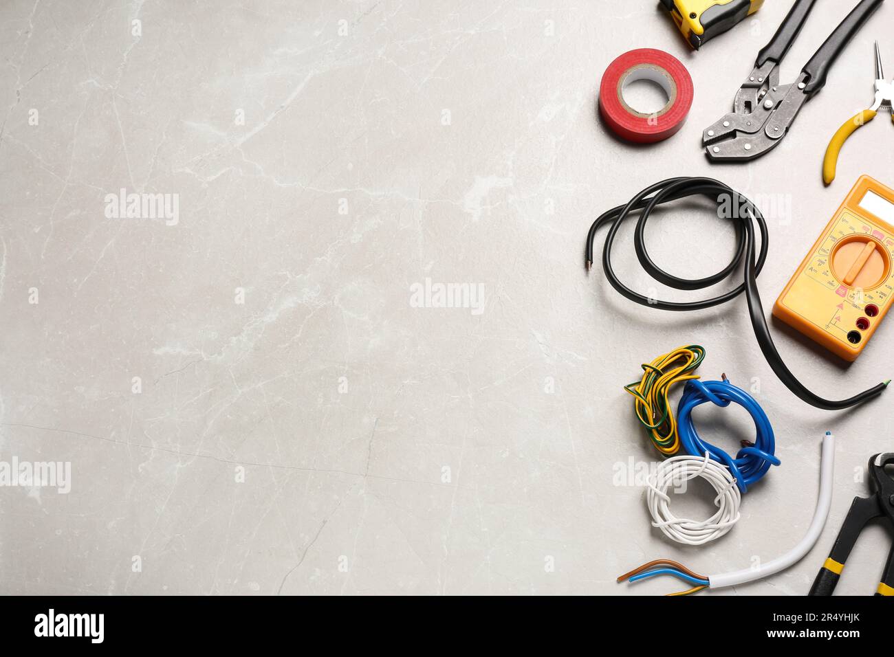 Different wires and electrical tools on light grey marble table, flat ...