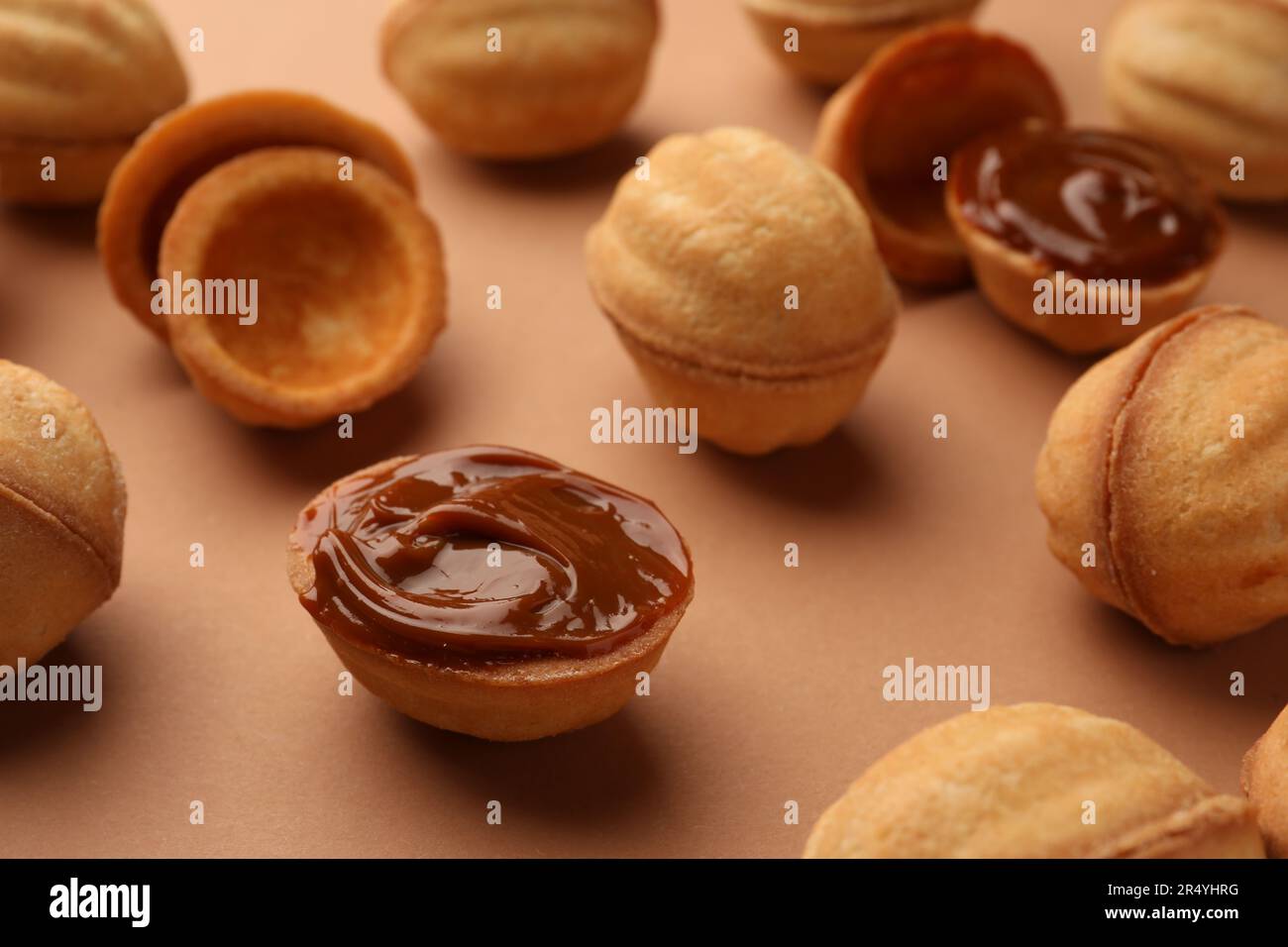 Homemade walnut shaped cookies with boiled condensed milk on pale brown ...