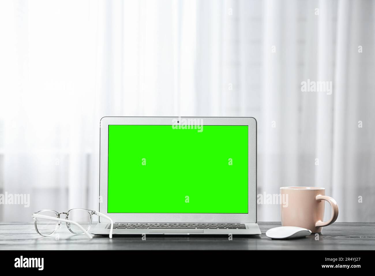 Laptop display with chroma key on desk in room. Comfortable workplace ...