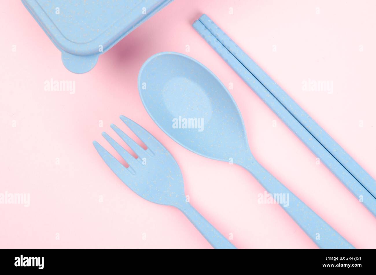 Blue Plastic spoons, forks and chopsticks set on pink color background ...