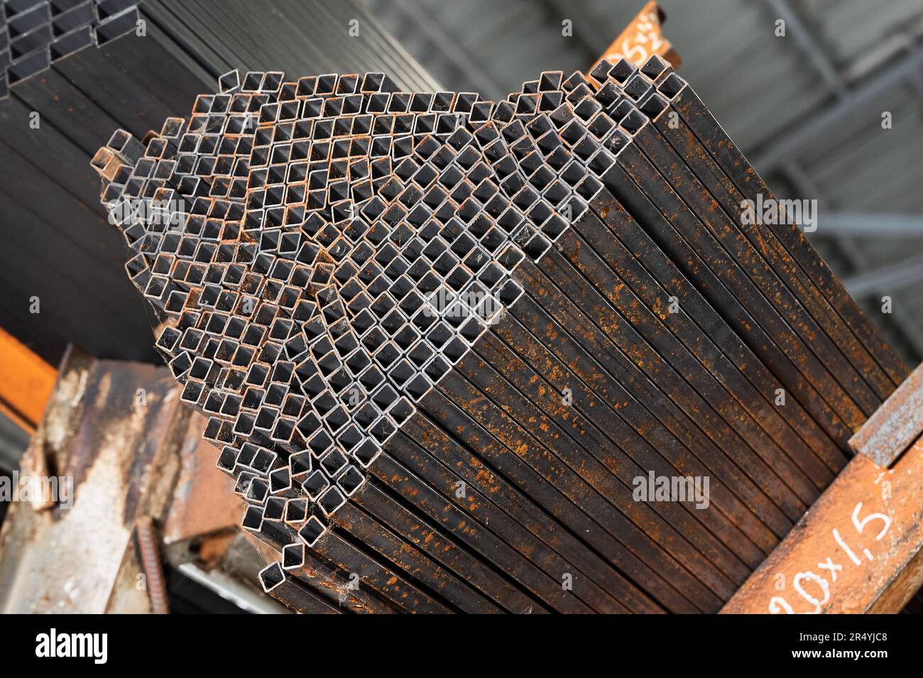 Square tubing pile on rack unit in cold factory warehouse Stock Photo ...