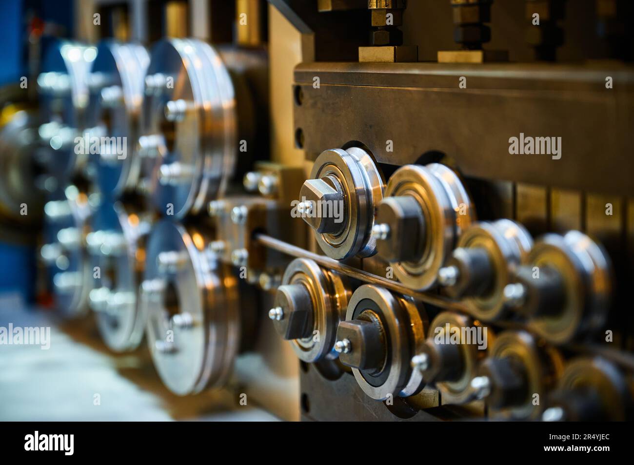 Metal cable pulled out through rollers line on machine tool Stock Photo ...