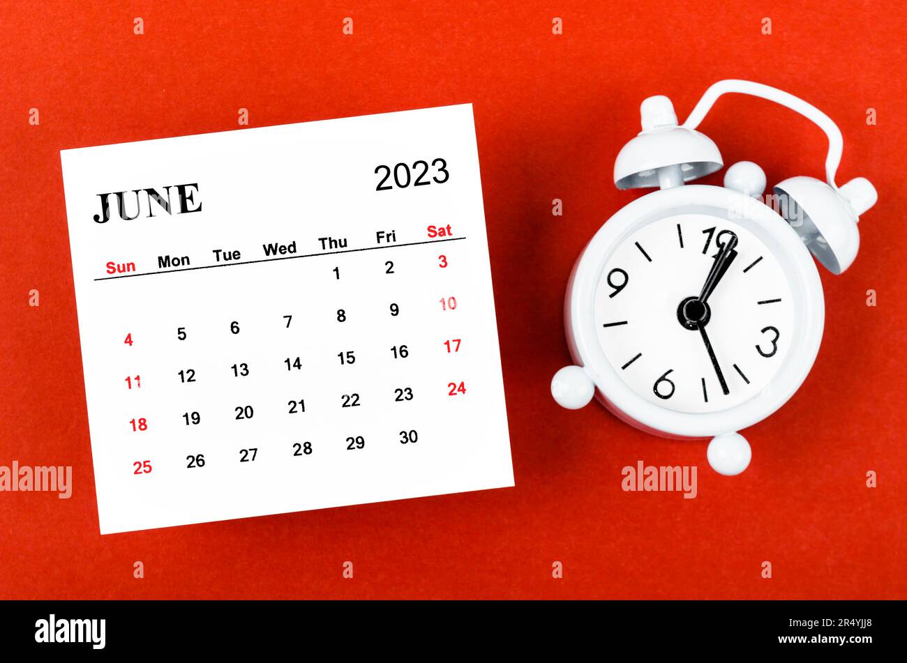 June 2023 Monthly calendar year with alarm clock on red background ...