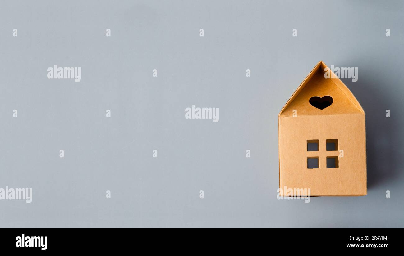Brown paper house origami on gray color background with empty space for ...