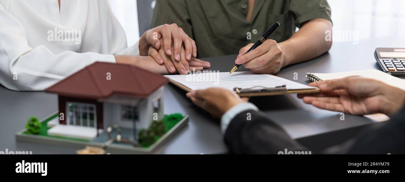 Panorama view of married couple signing house loan contract with real ...