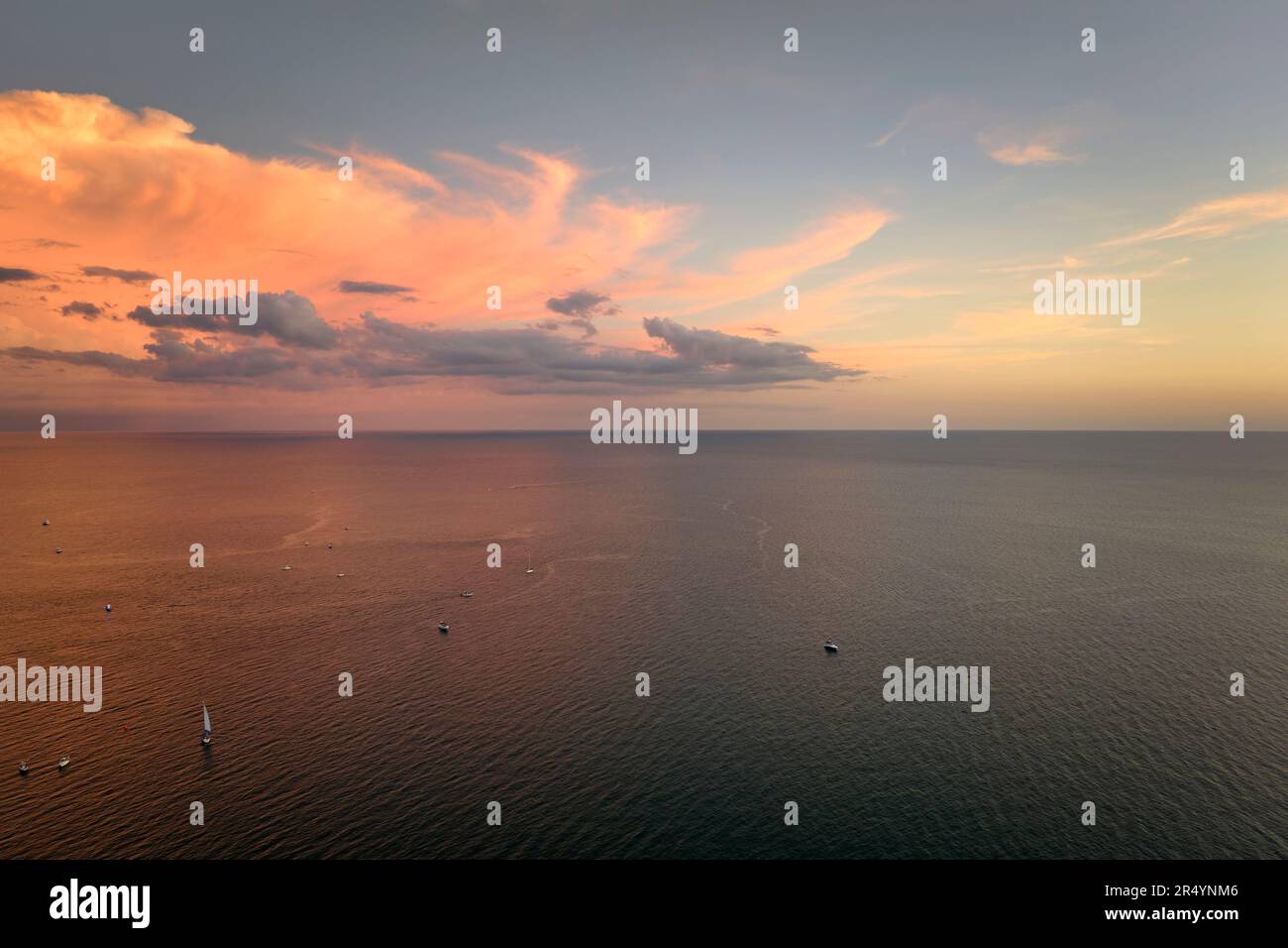 Aerial view of small yachts at sunset floating on sea waves with ripple ...