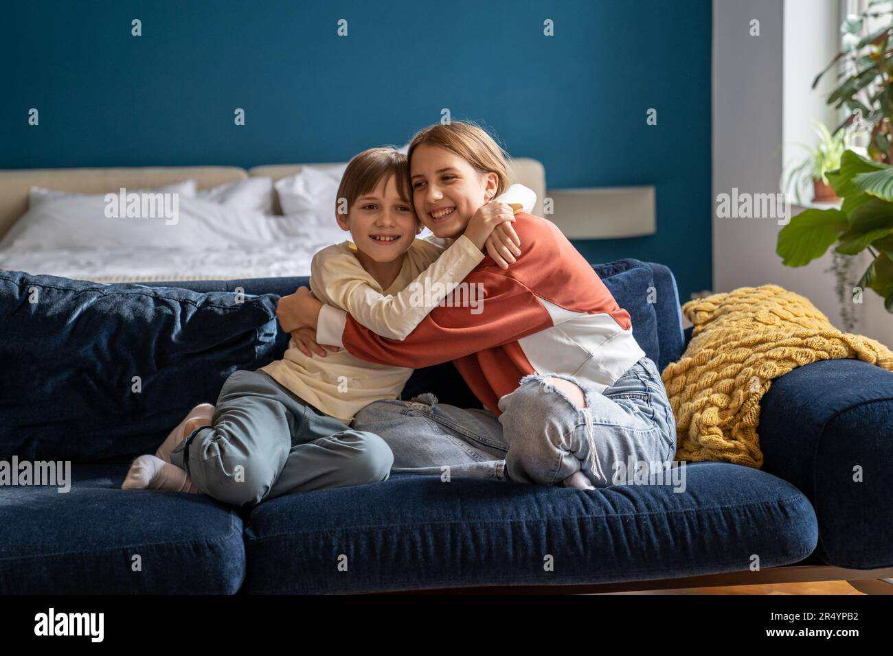 Happy siblings hugging embracing feeling love, care, connection. Small brother cuddling teen ...