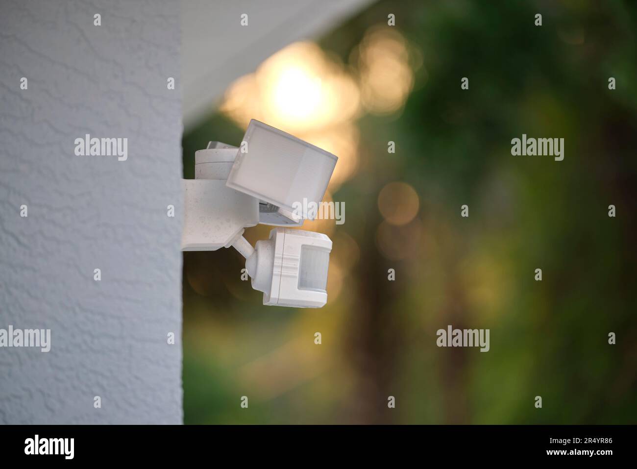 Motion sensor with light detector mounted on exterior wall of private ...