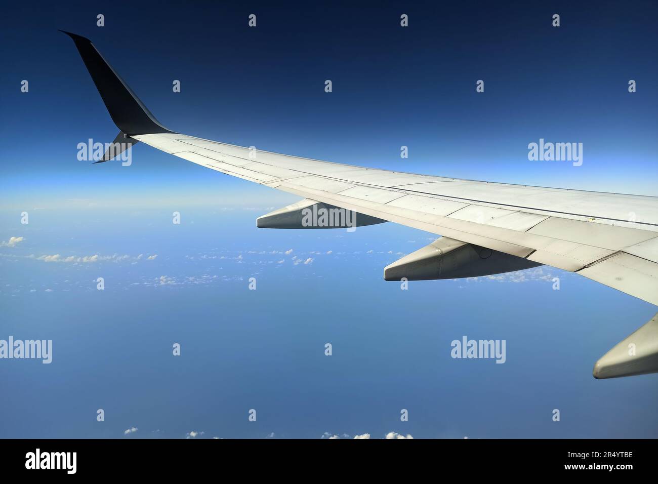 View through airplane window of commercial jet plane wing flying high ...