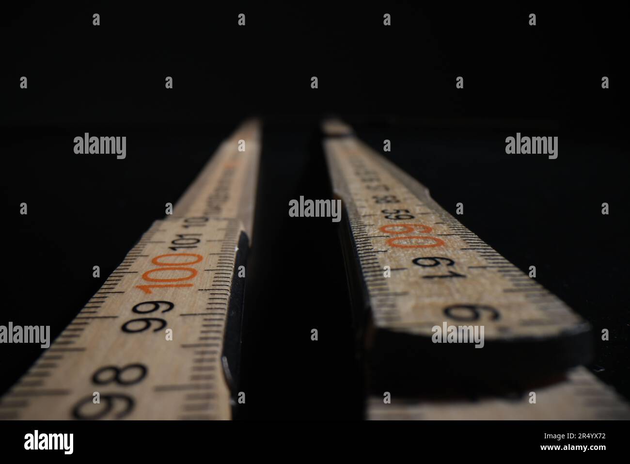 Old wooden folding ruler with scale on black background Stock Photo - Alamy