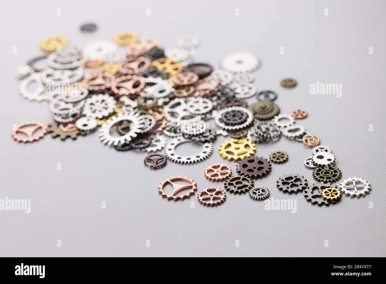 Pile of different size metal cogwheels on light grey table Stock Photo ...