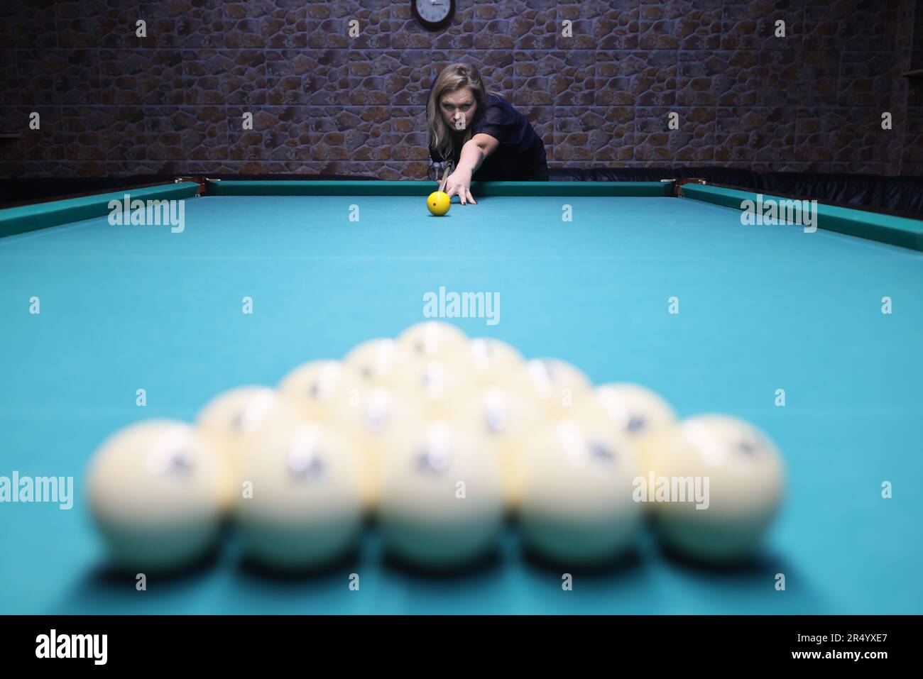 Concentrated female player directs ball to white pyramid made on blue ...