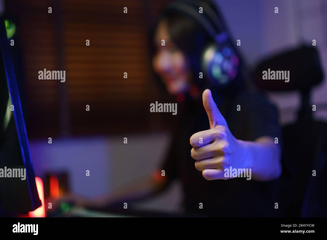 Female cyber hacker gamer in headphone showing thumb up after hacking ...