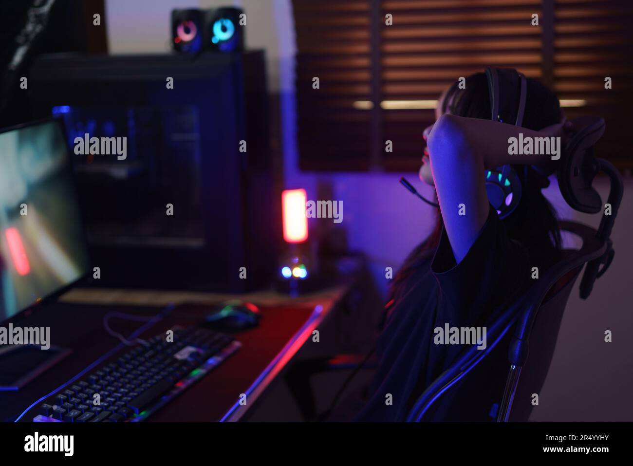 Female cyber hacker gamer holding hands behind the head while watching ...