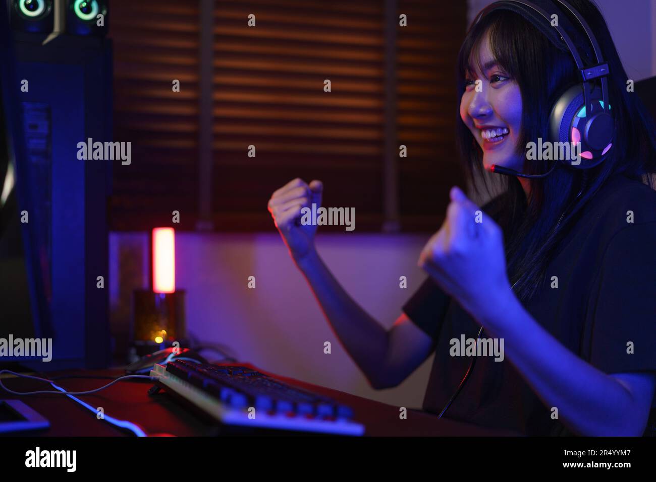 Female cyber hacker gamer in headphones making win gesture after ...