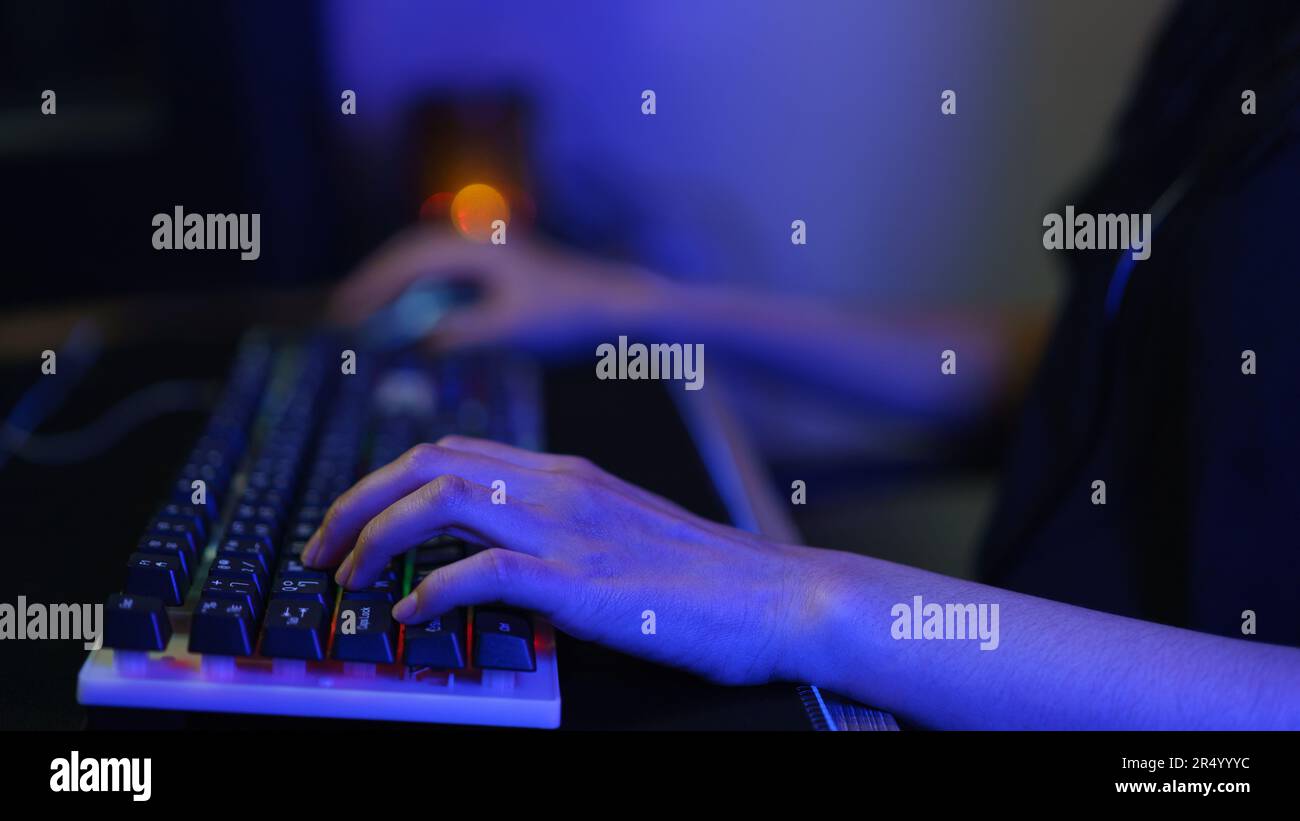Hand of female cyber hacker gamer on keyboard to playing games or ...