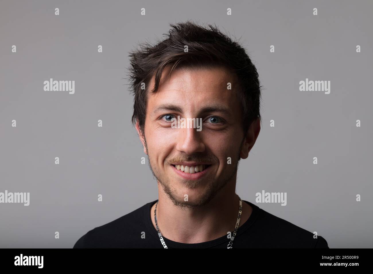 Young tanned man smiling. Confident, handsome and happy, he has his ...