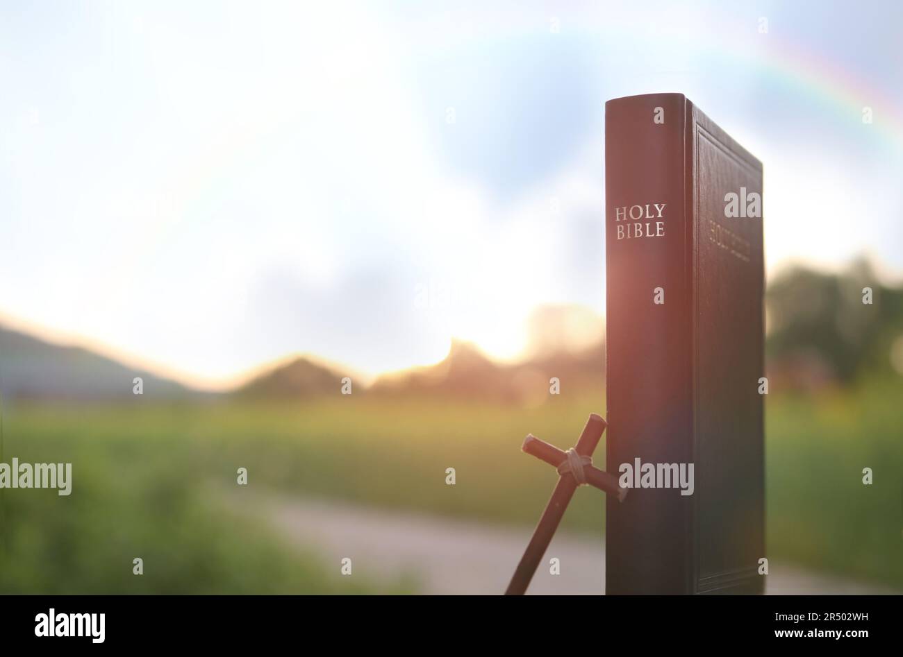 Bible book, sky, rainbow and cross of Jesus Christ and beautiful nature ...