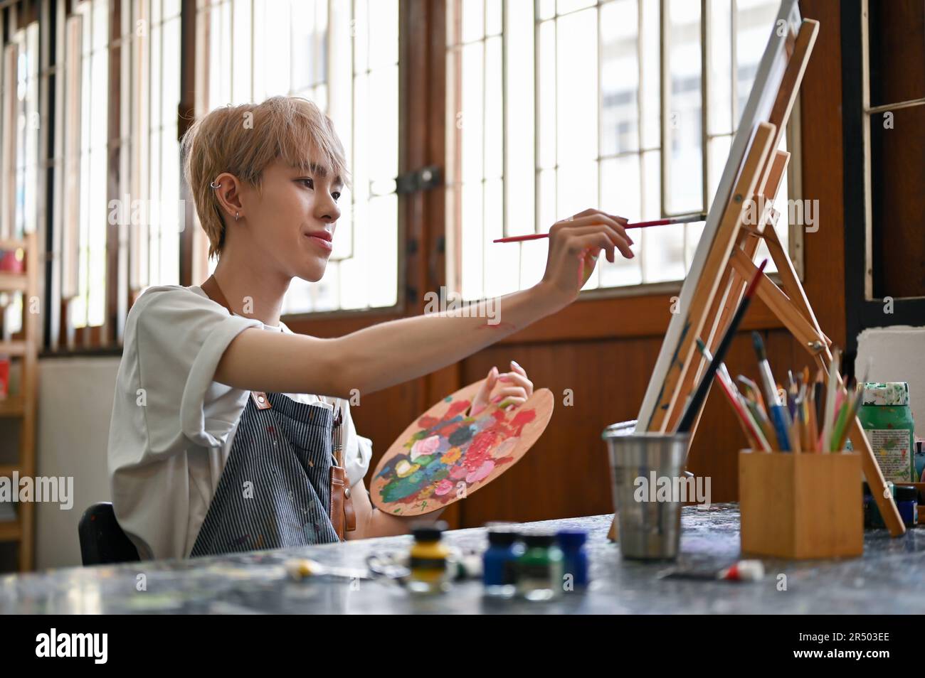 A creative and talented young Asian gay man or queer art student is ...