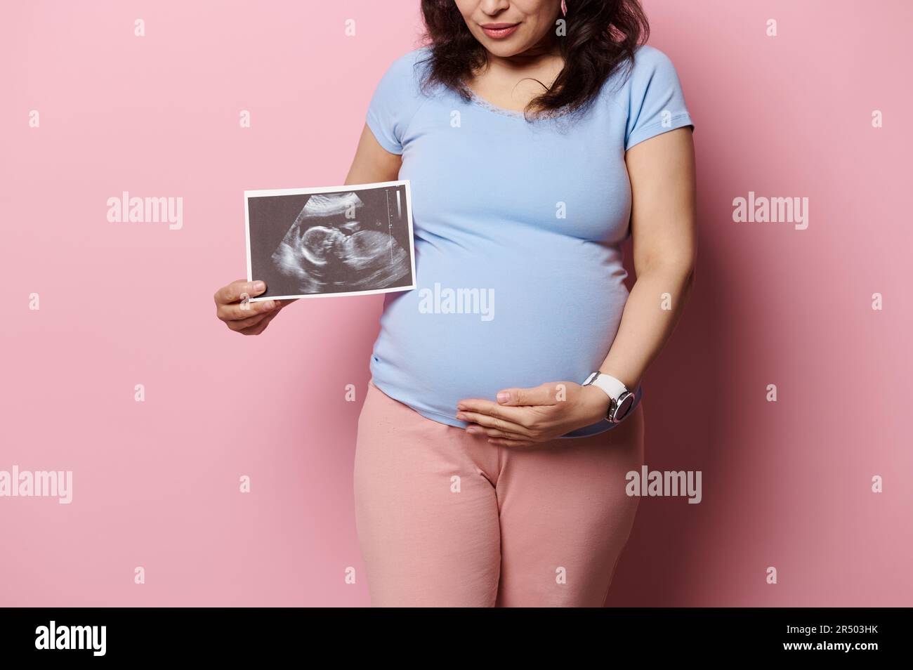Close-up studio shot of the belly of a pregnant woman showing ...