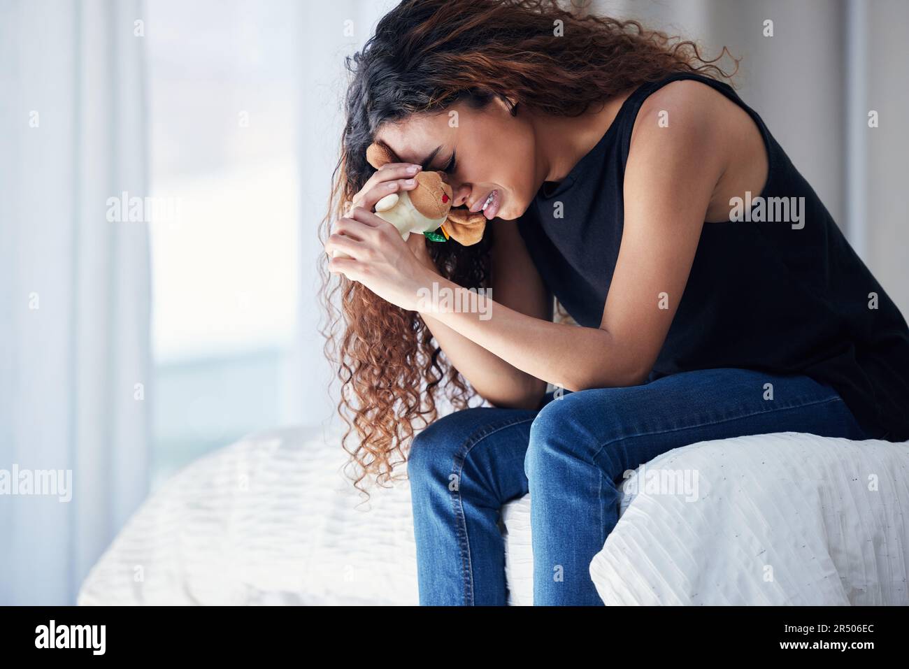 Crying, depression and woman with teddy bear on bed for grief ...
