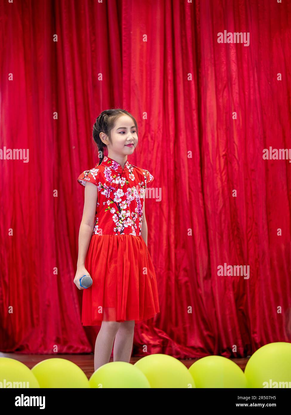 The Asian kid girl sing a song on stage at her school activity day ...