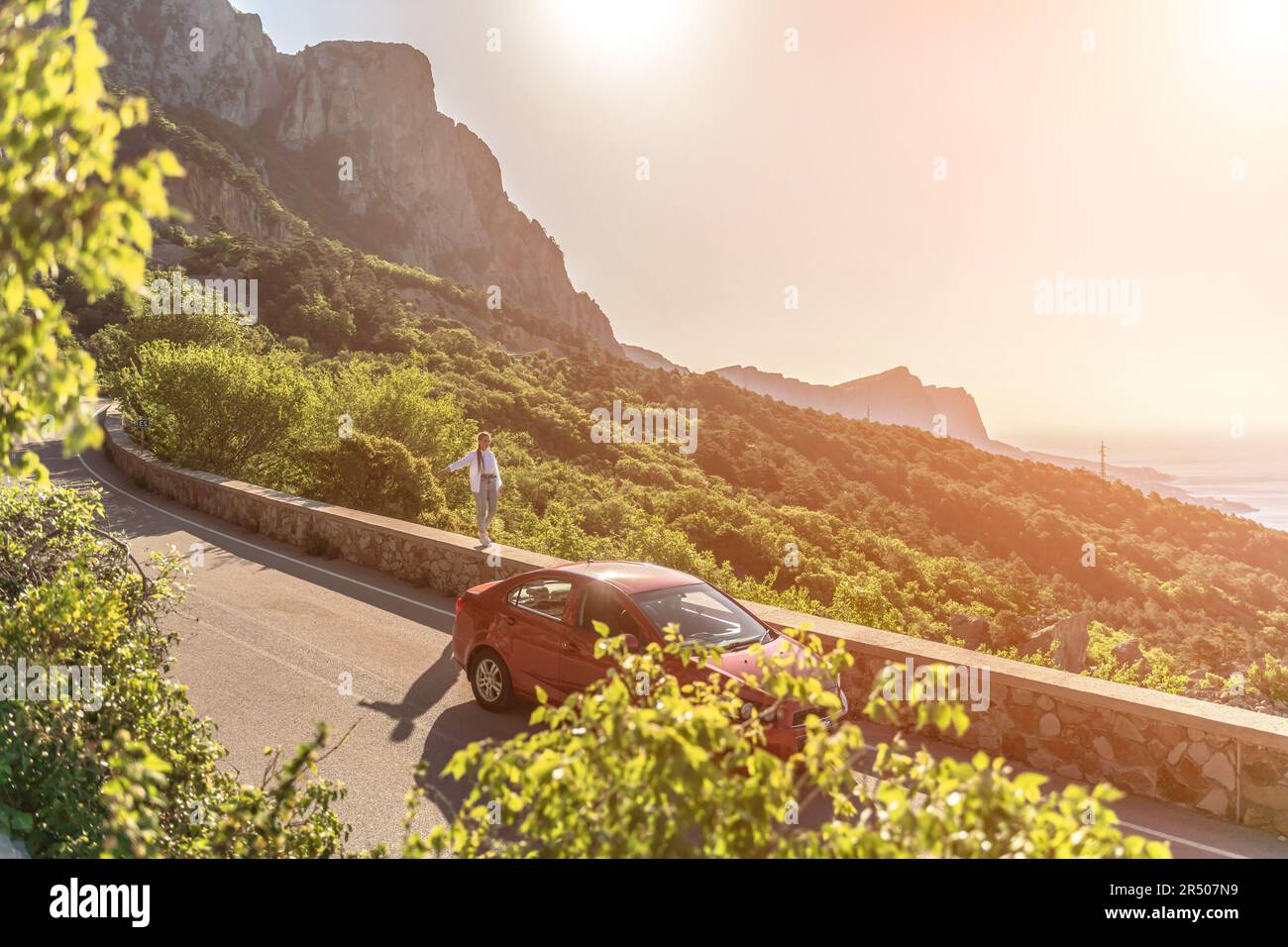 Mountain road woman. She walks along a parapet road in the middle of a ...