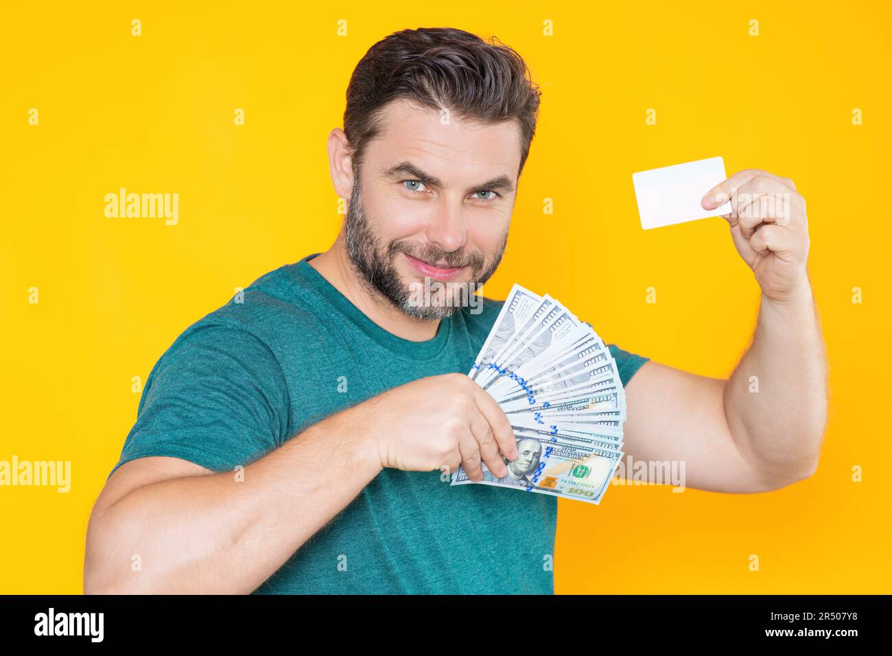 Man hold money on yellow studio isolated background. Portrait of rich ...