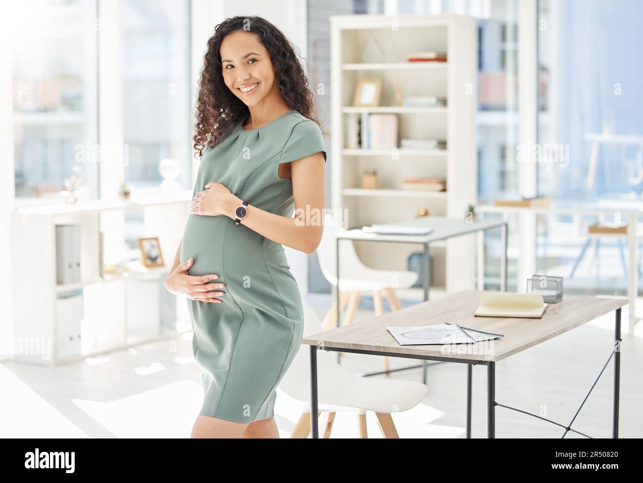Portrait, happy and a pregnant business woman in her office getting ...