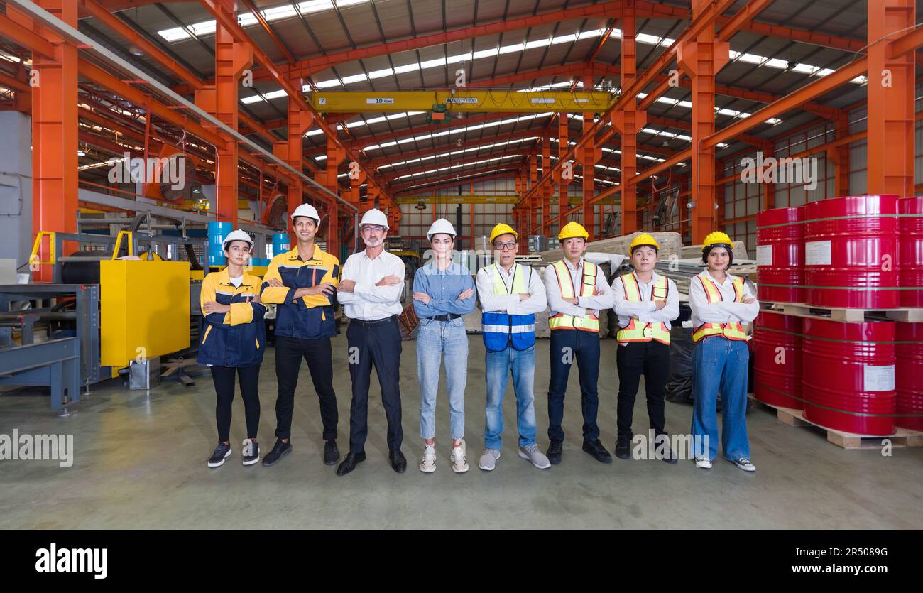 Group of male and female factory labor stand smiling together with arms ...