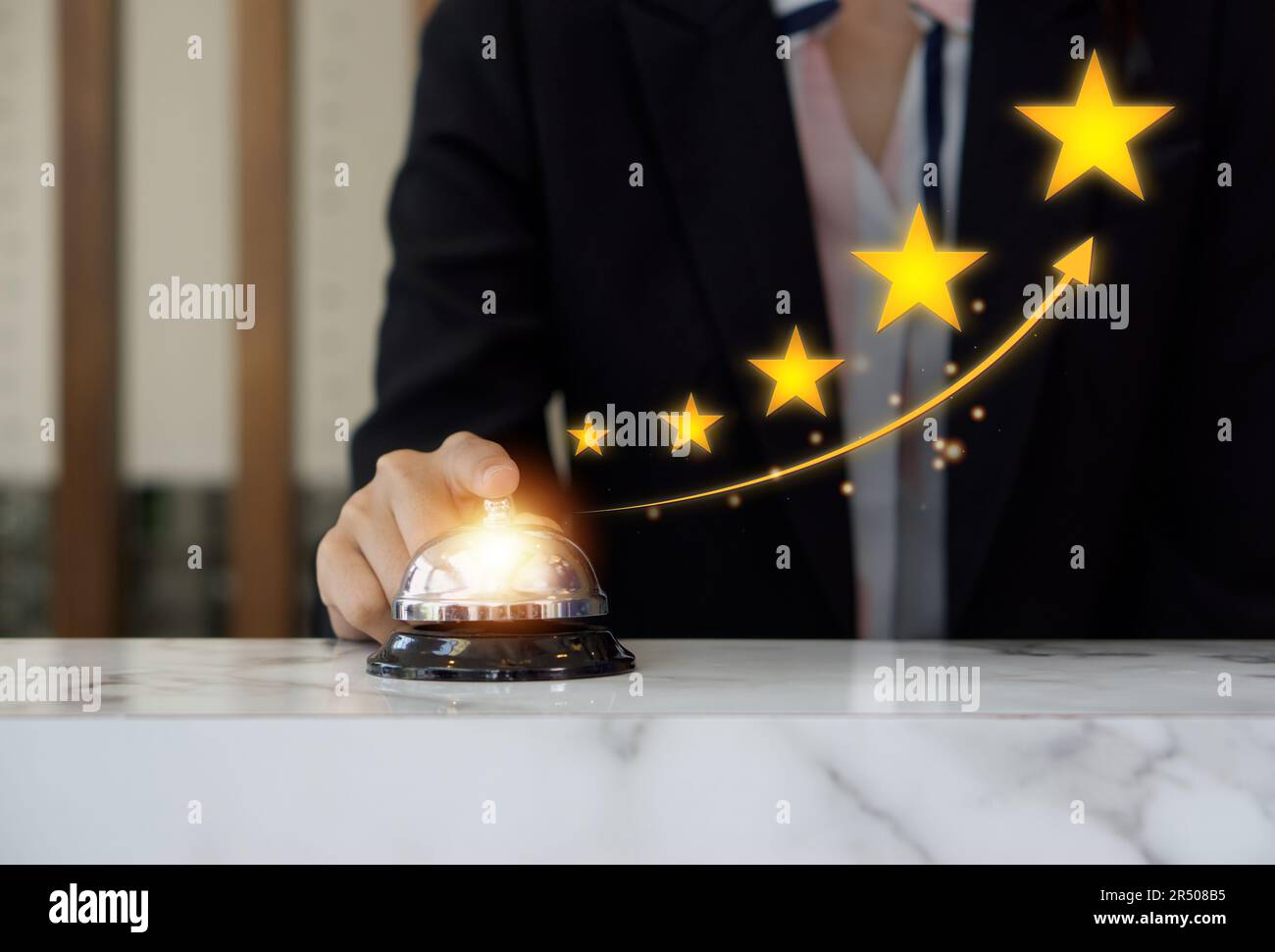 Businesswoman hand ringing silver service bell on hotel reception desk ...