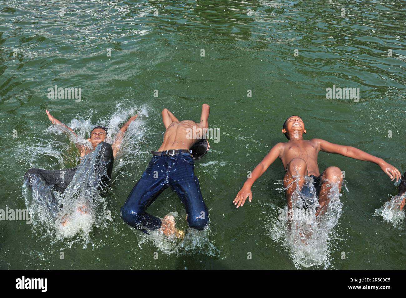 Sylhet, Bangladesh. 30th May 2023. Local children playing in a pond during a summer heat wave in ...