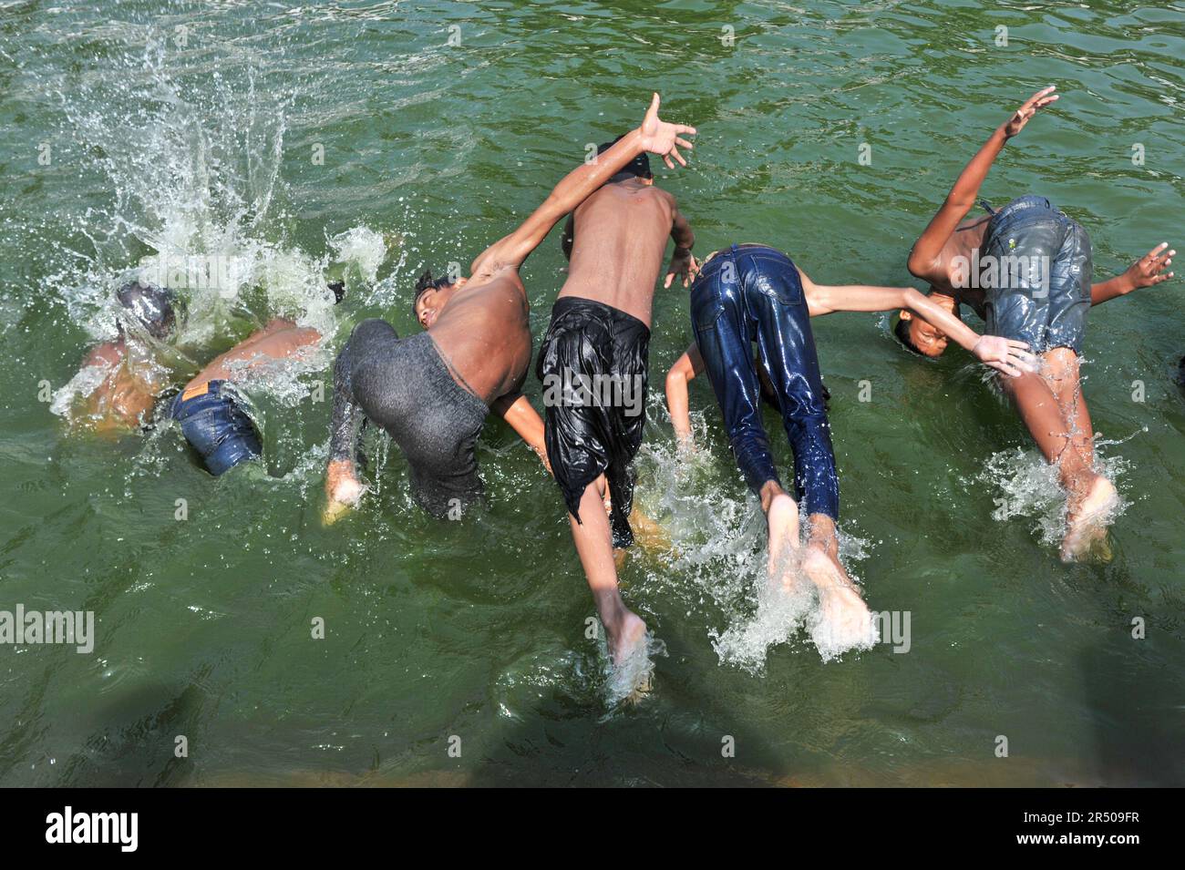 Sylhet, Bangladesh. 30th May 2023. Local children playing in a pond during a summer heat wave in ...