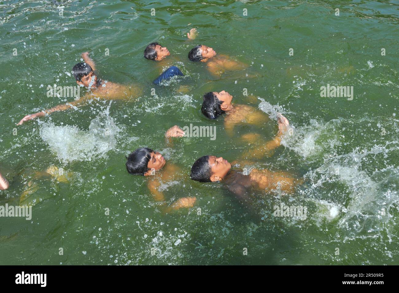 Sylhet, Bangladesh. 30th May 2023. Local children playing in a pond during a summer heat wave in ...