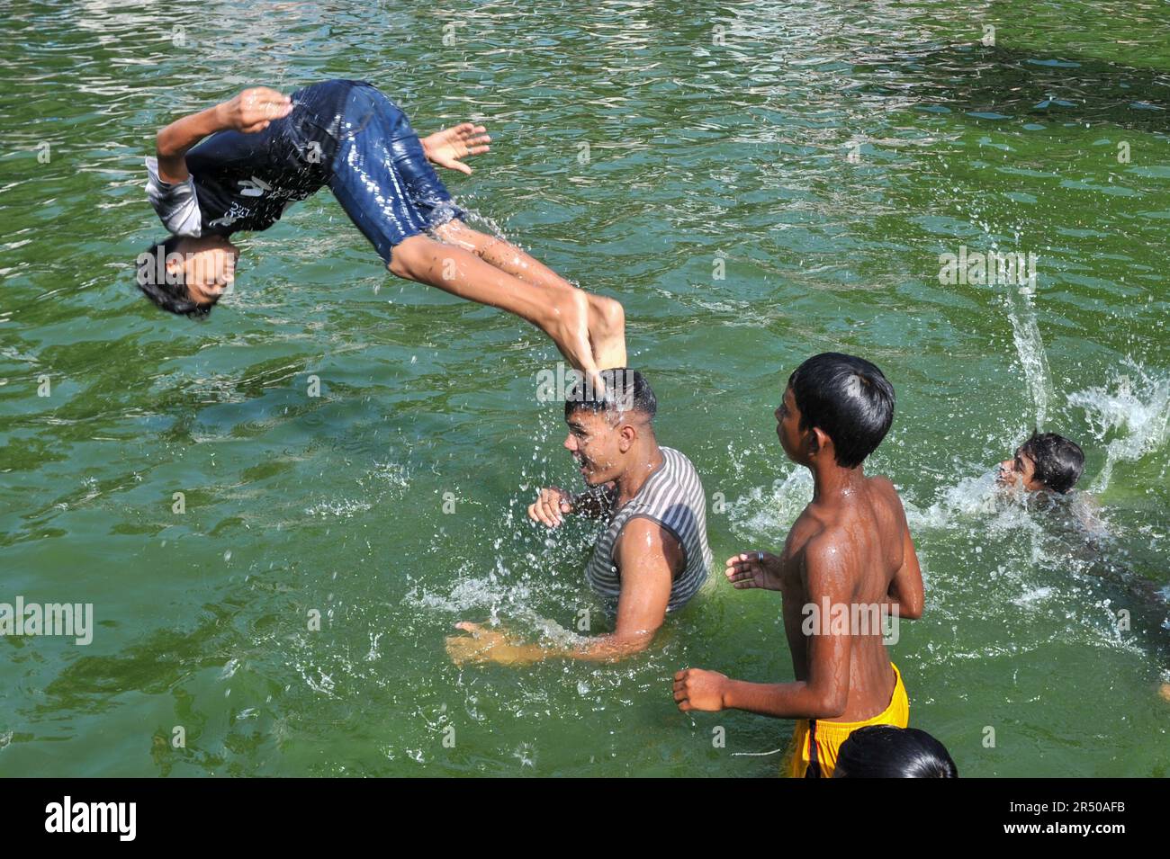 Sylhet, Bangladesh. 30th May 2023. Local children playing in a pond during a summer heat wave in ...